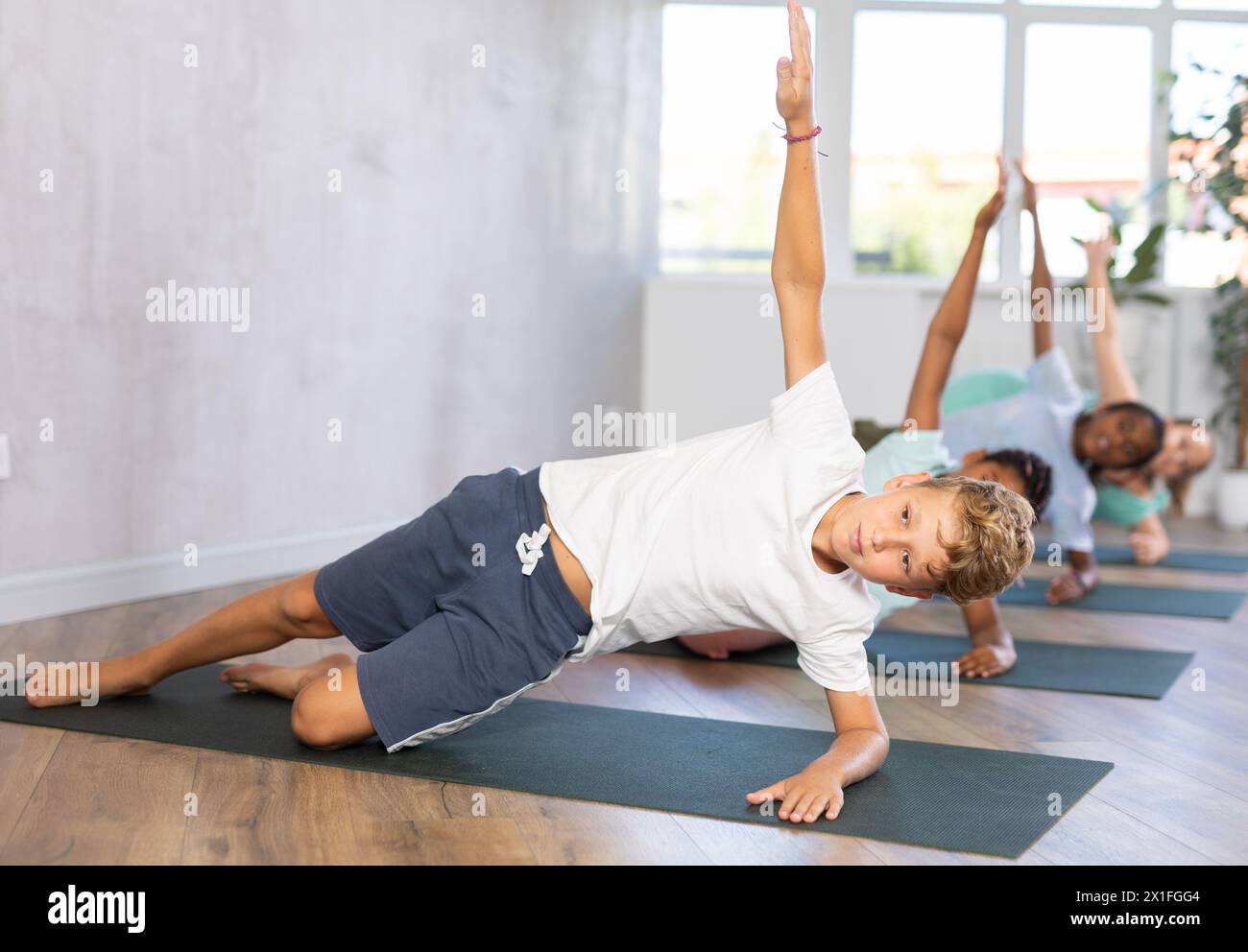 Active children exercising during yoga class in fitness center ...