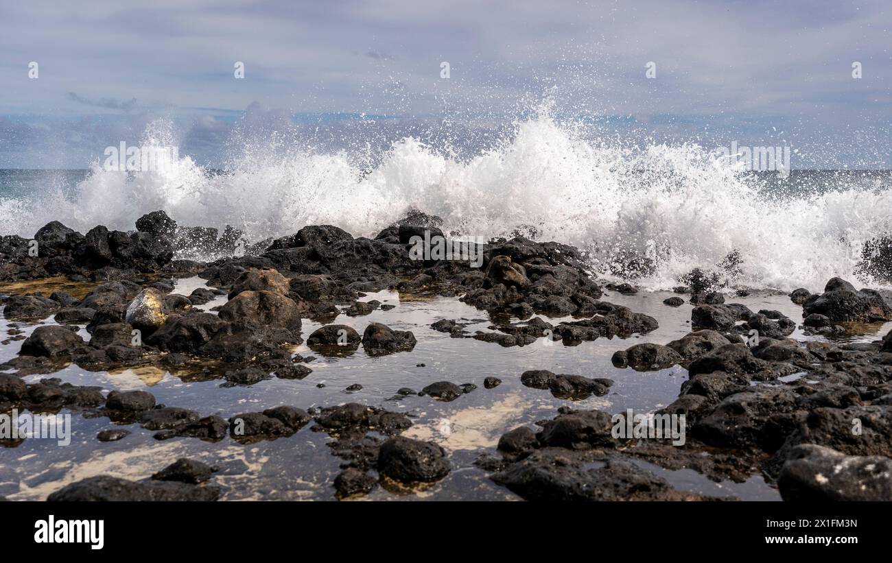 Rough waves from the Pacific Ocean crash against the rocky shoreline of ...