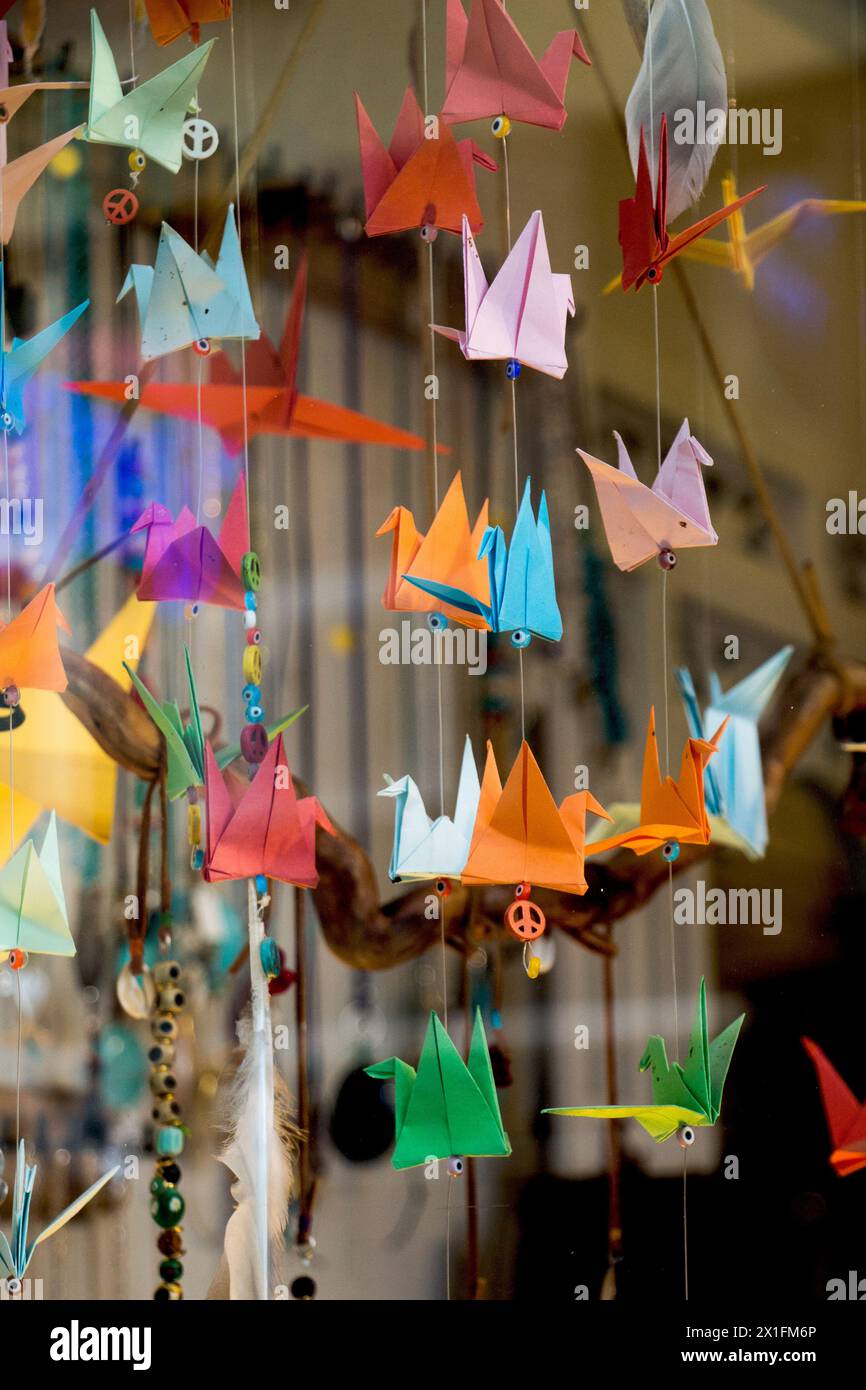 Colorful paper origami birds tied to strings hanging in air Stock Photo ...