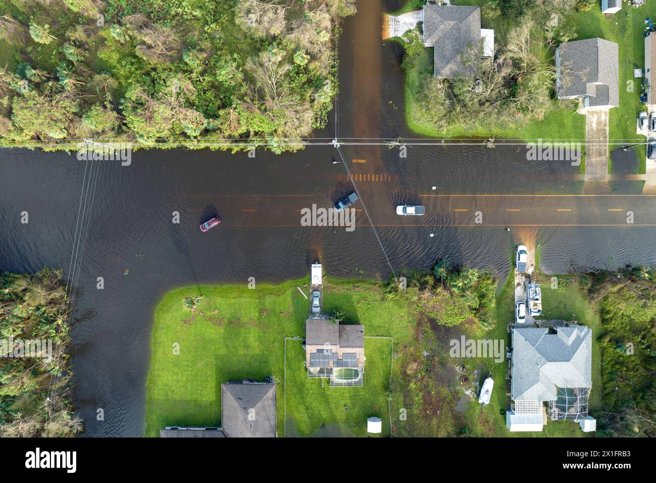 Aerial view of flooded street after hurricane rainfall with driving cars in Florida residential ...