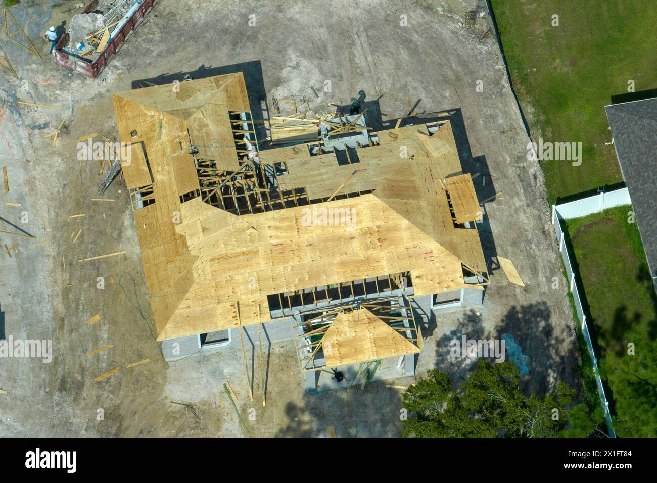 Builders working on roof construction of unfinished residential house ...