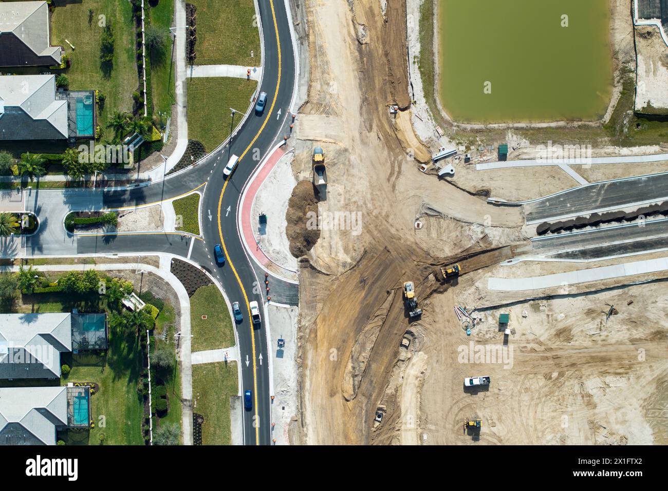 Industrial construction roadworks at roundabout intersection with moving cars in Venice, Florida ...