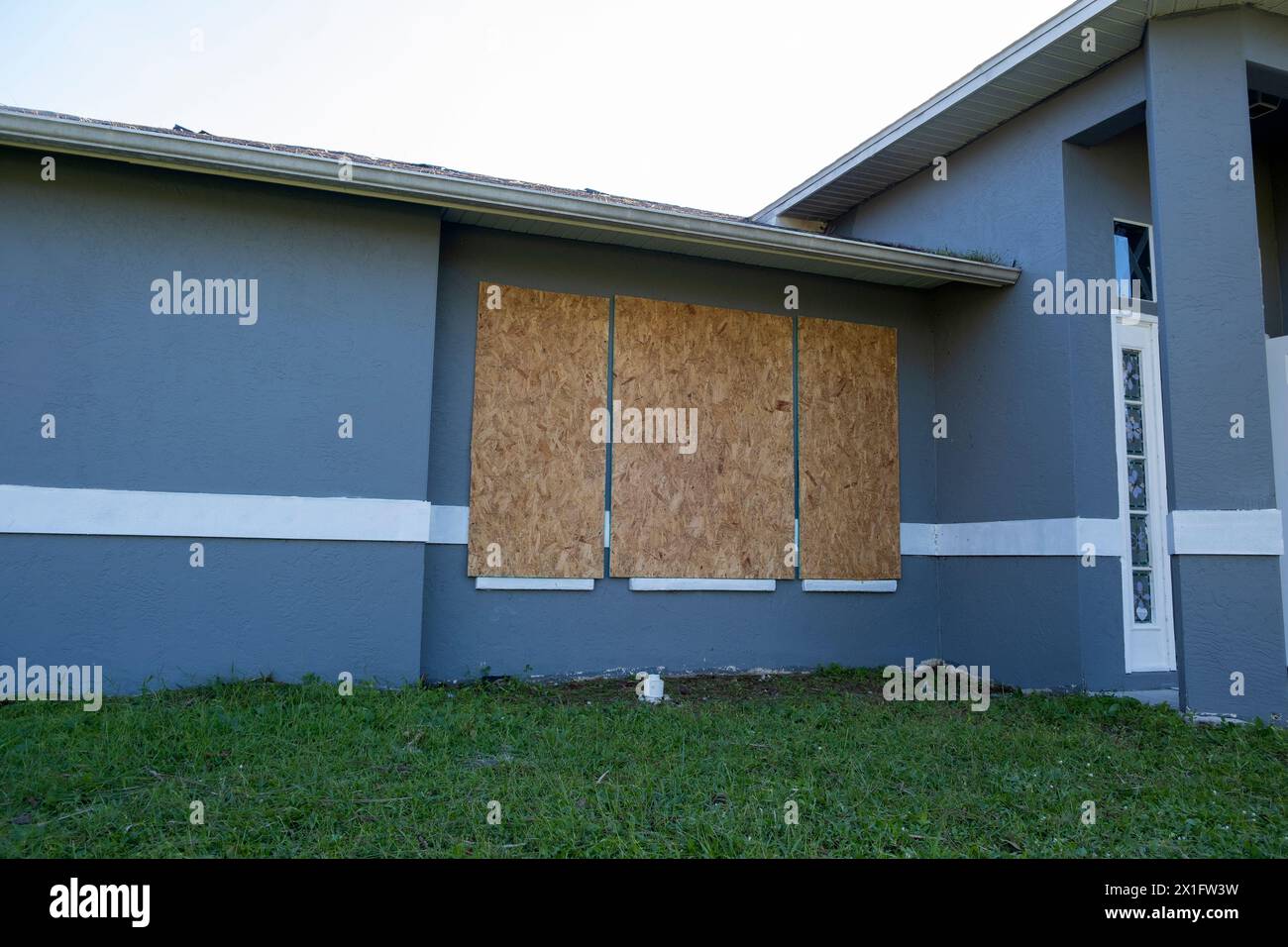 Plywood mounted as storm shutters for hurricane protection of house ...