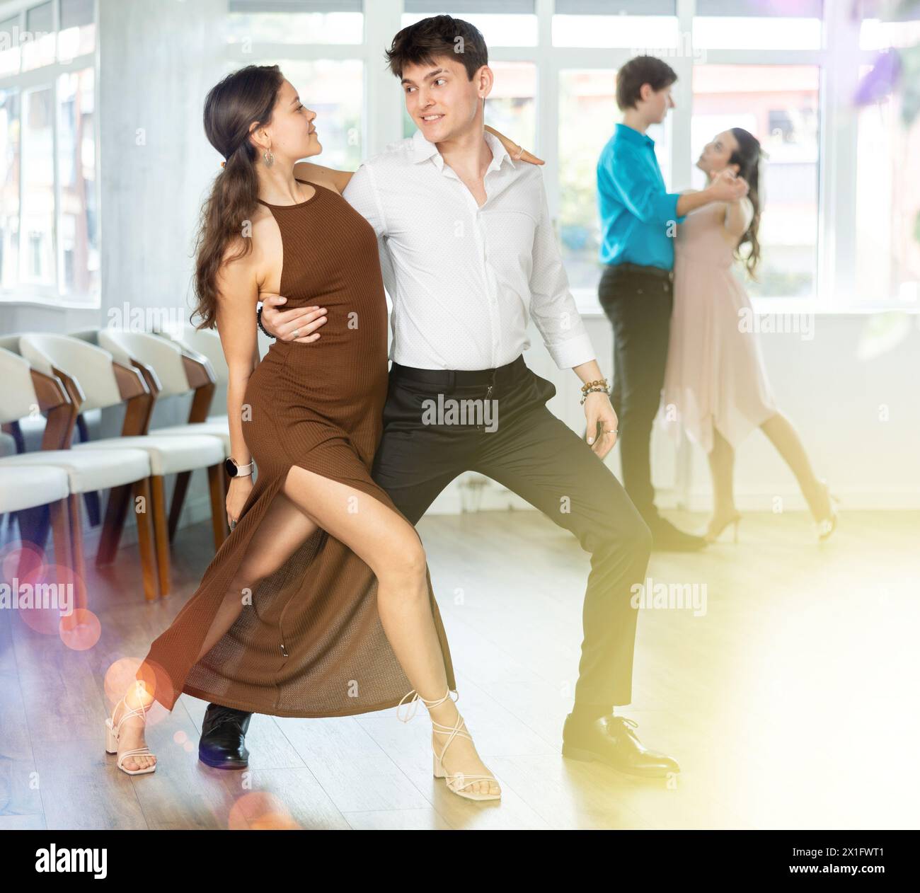 Couple in evening dresses enjoys pair dance tango, interacting with ...