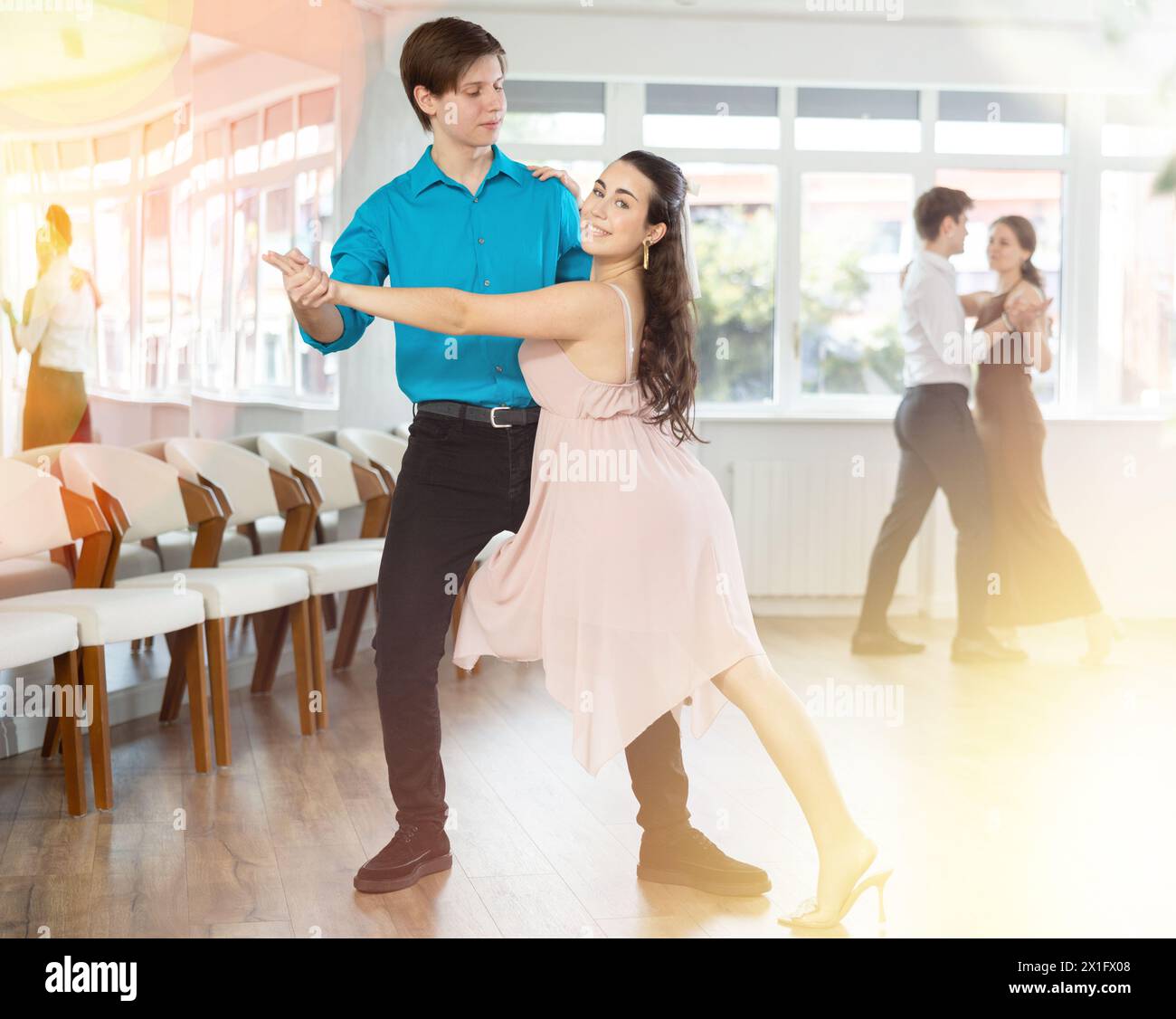 Couple in evening dresses enjoys pair dance tango, interacting with ...