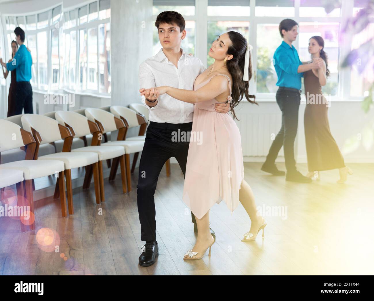 Couple in evening dresses enjoys pair dance tango, interacting with ...