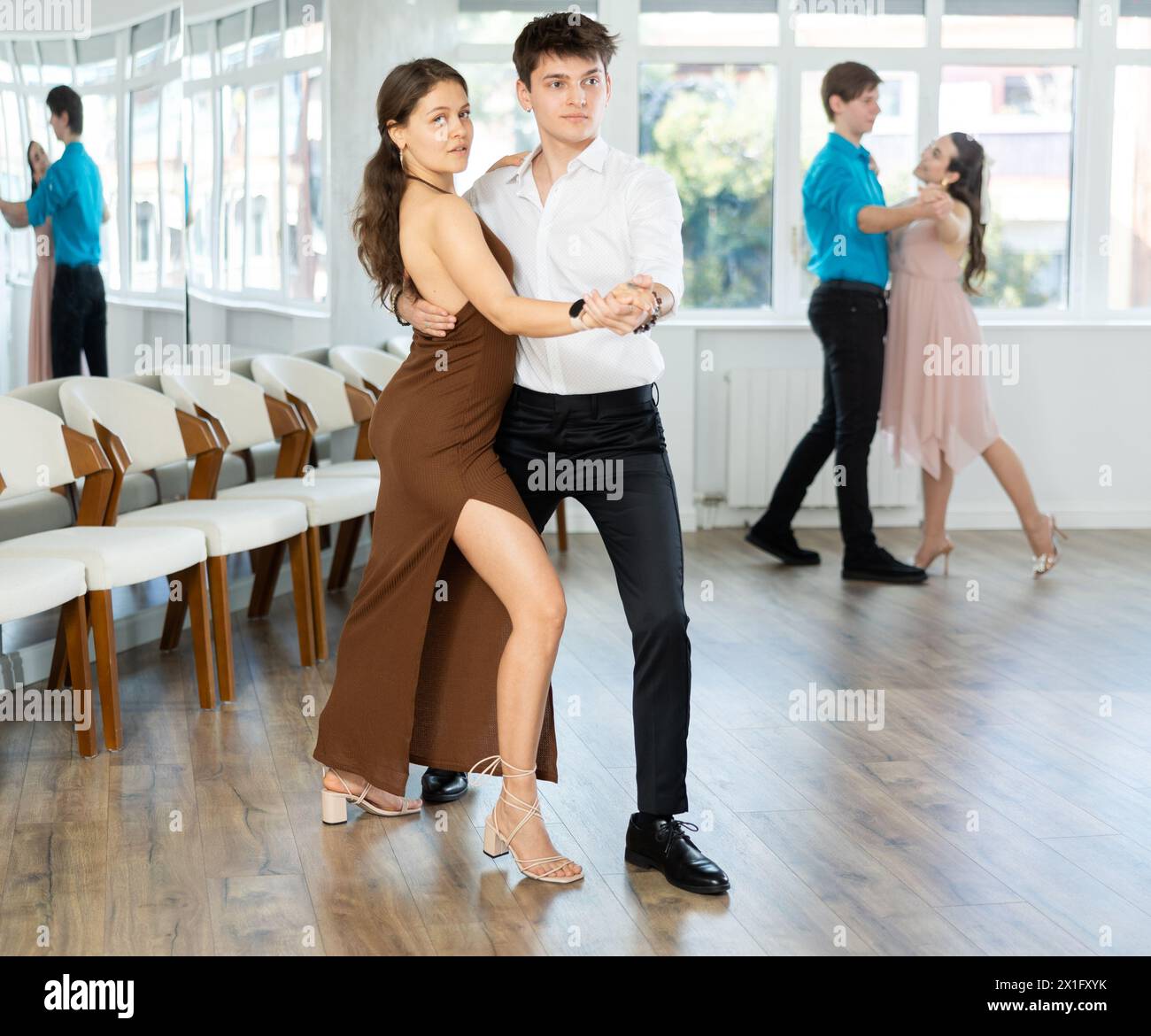 Couple in evening dresses enjoys pair dance tango, interacting with ...