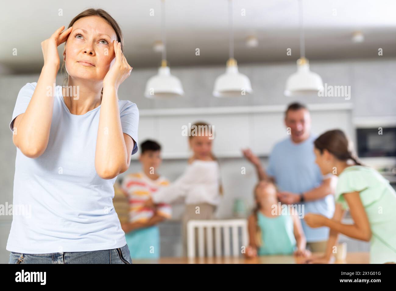 Irritated mom is tired of noise and screams of the children at home ...