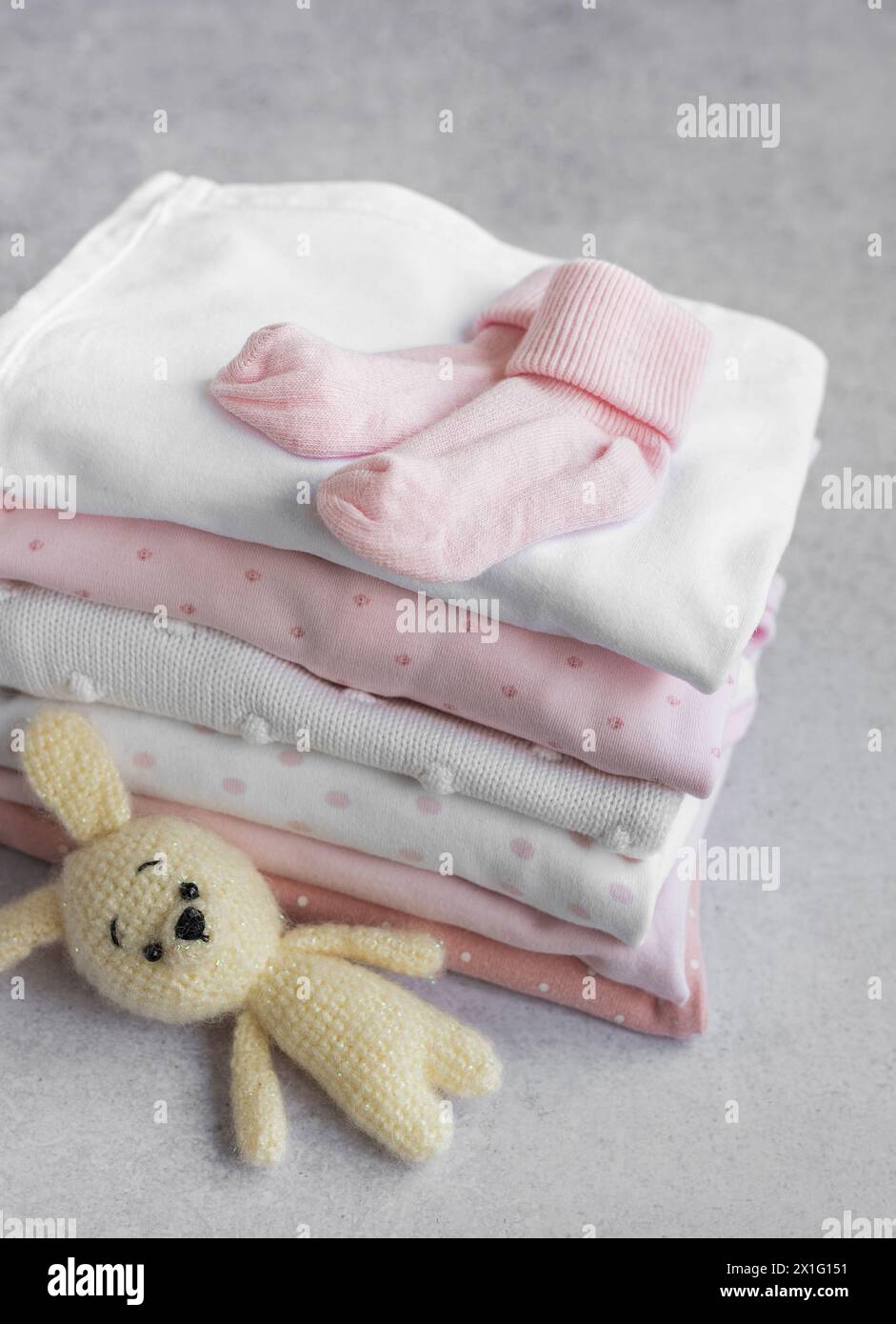 Stack of Baby bodysuits on a grey background. Baby crocketed toy of ...