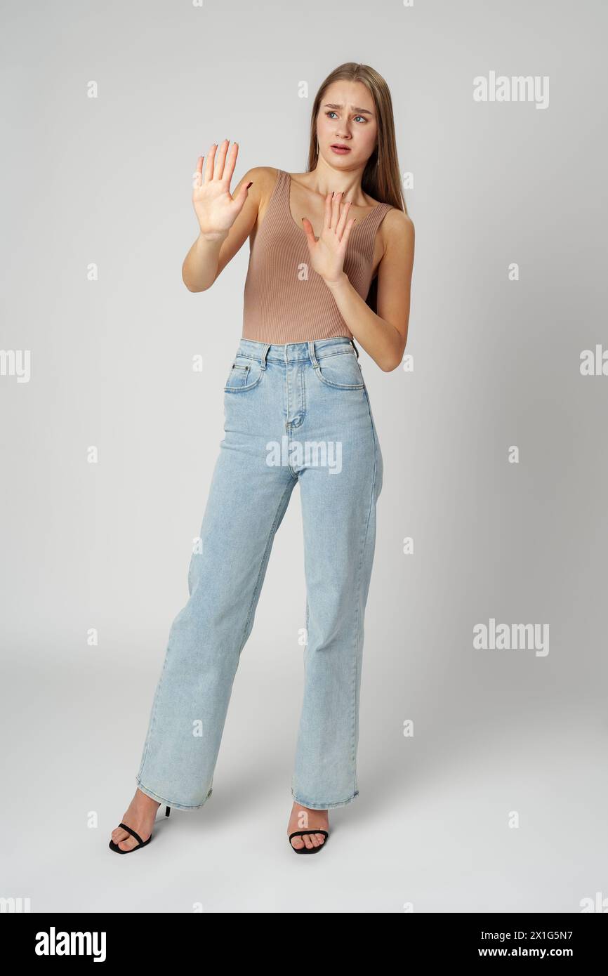 Young Woman in Fashionable Outfit Standing Against a Neutral Backdrop ...