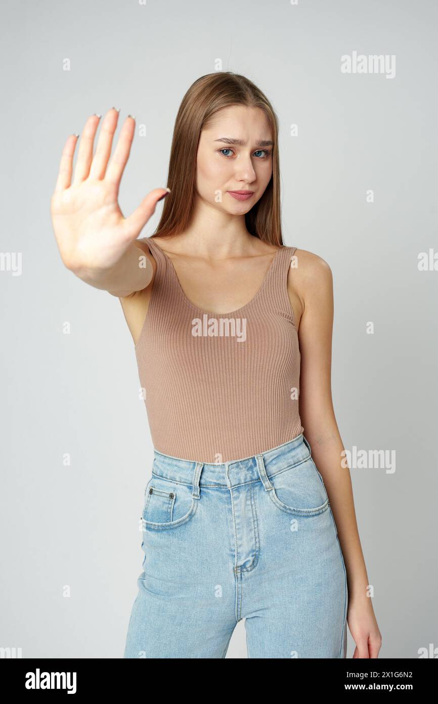 Young Woman in Fashionable Outfit Standing Against a Neutral Backdrop ...