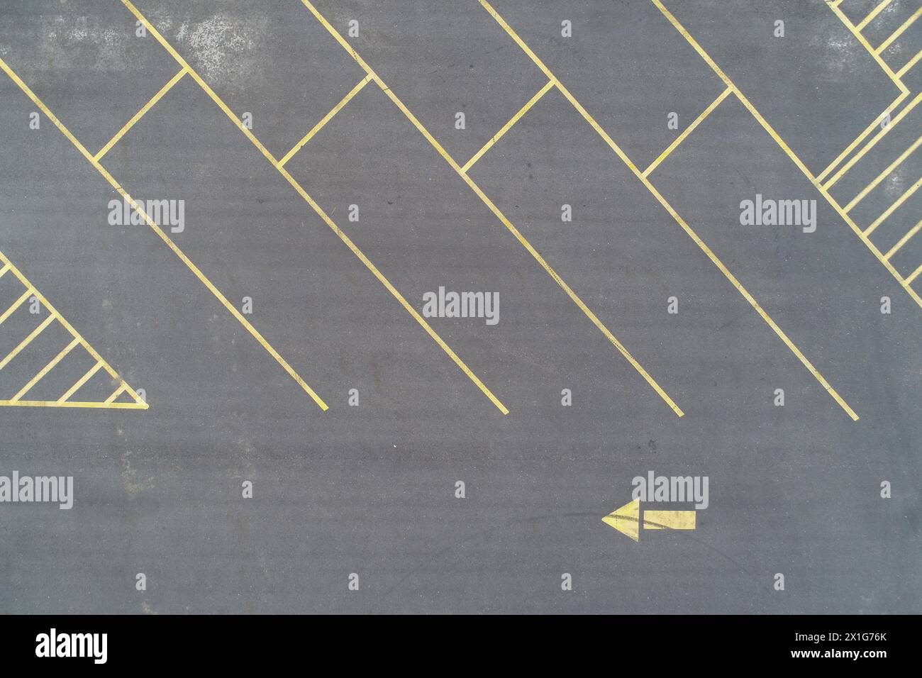 Asphalt parking lot with yellow lines an leftpointing arrow Stock Photo ...