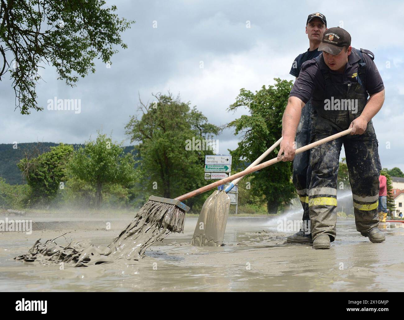 Rescue workers clean the streets from mud after the flood receded, 06 ...