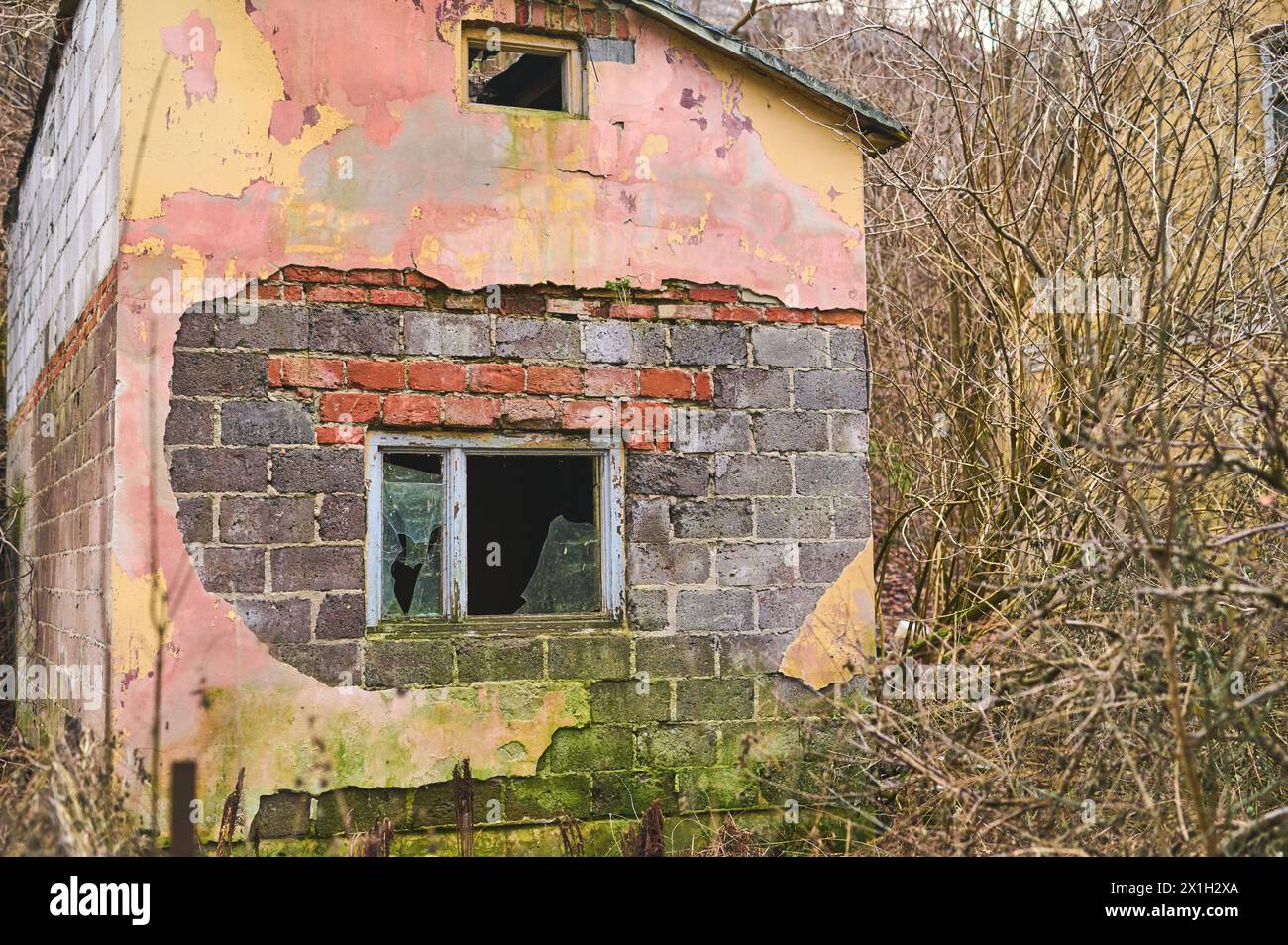Broken window in an old crumbling cinder block building Stock Photo - Alamy