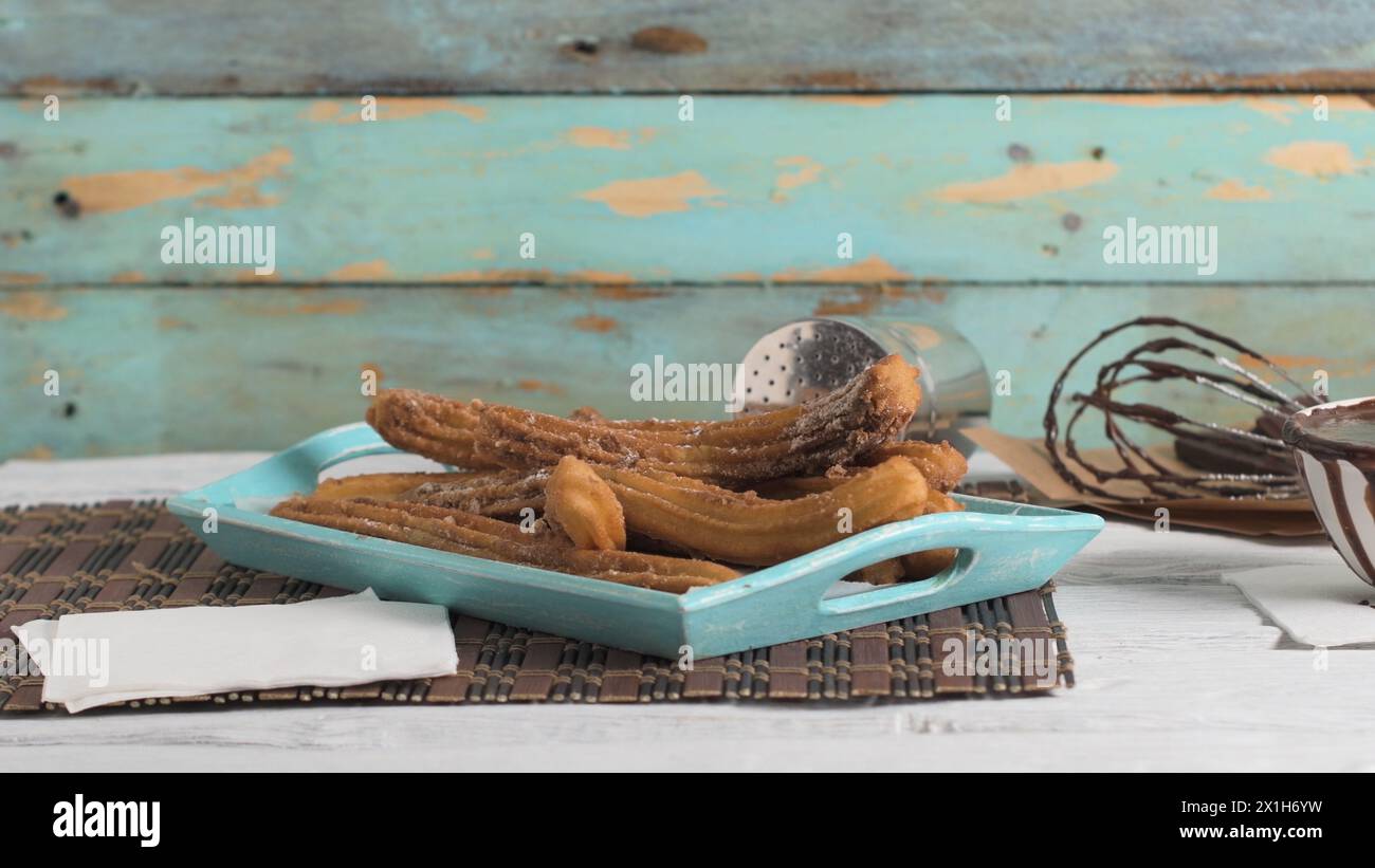 Traditional churros with hot chocolate dipping sauce on wooden counter ...