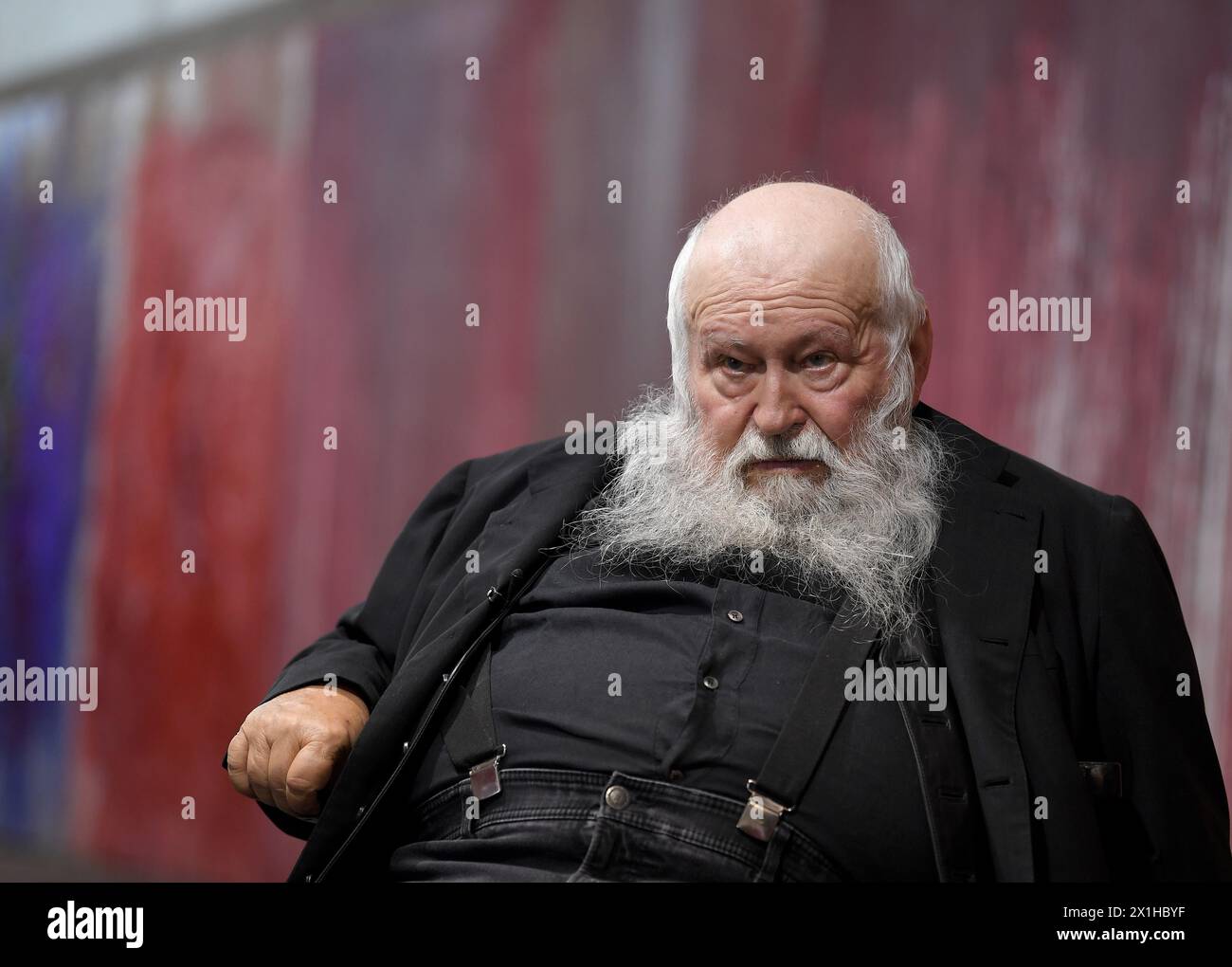 Austrian artist Hermann Nitsch sitting in front of his artworks during ...