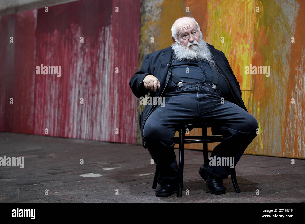 Austrian artist Hermann Nitsch sitting in front of his artworks during ...