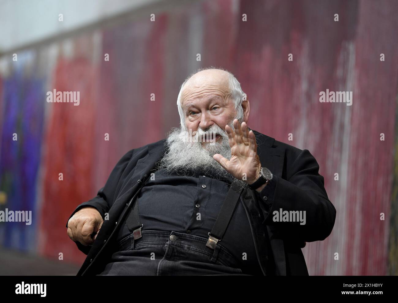 Austrian artist Hermann Nitsch sitting in front of his artworks during ...