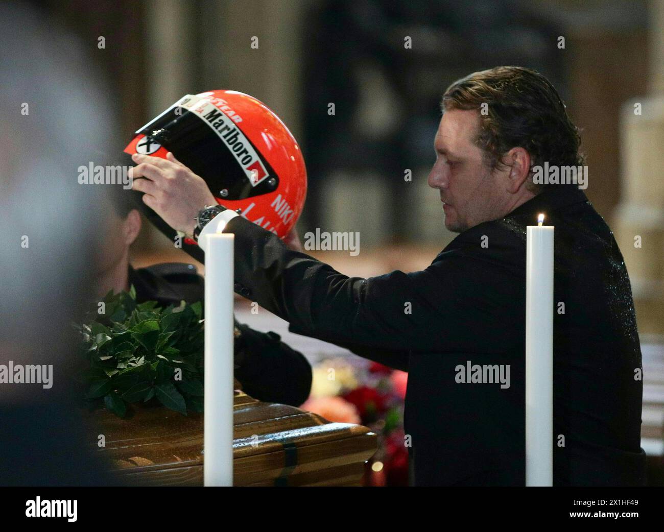 Lukas Lauda places his father's race helmet on his coffin at the start ...
