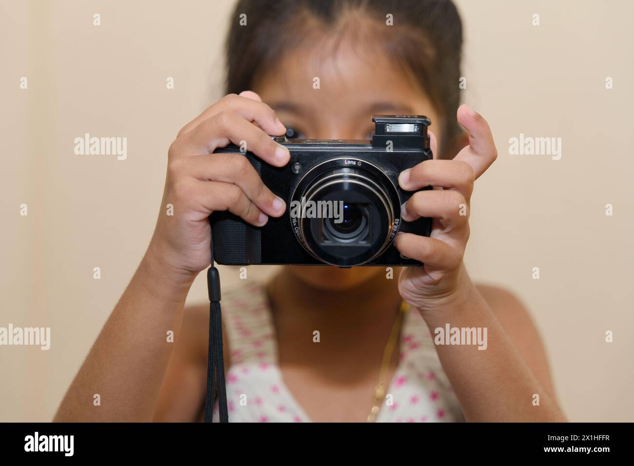 A close-up view of a classic camera held by a child, highlighting the ...