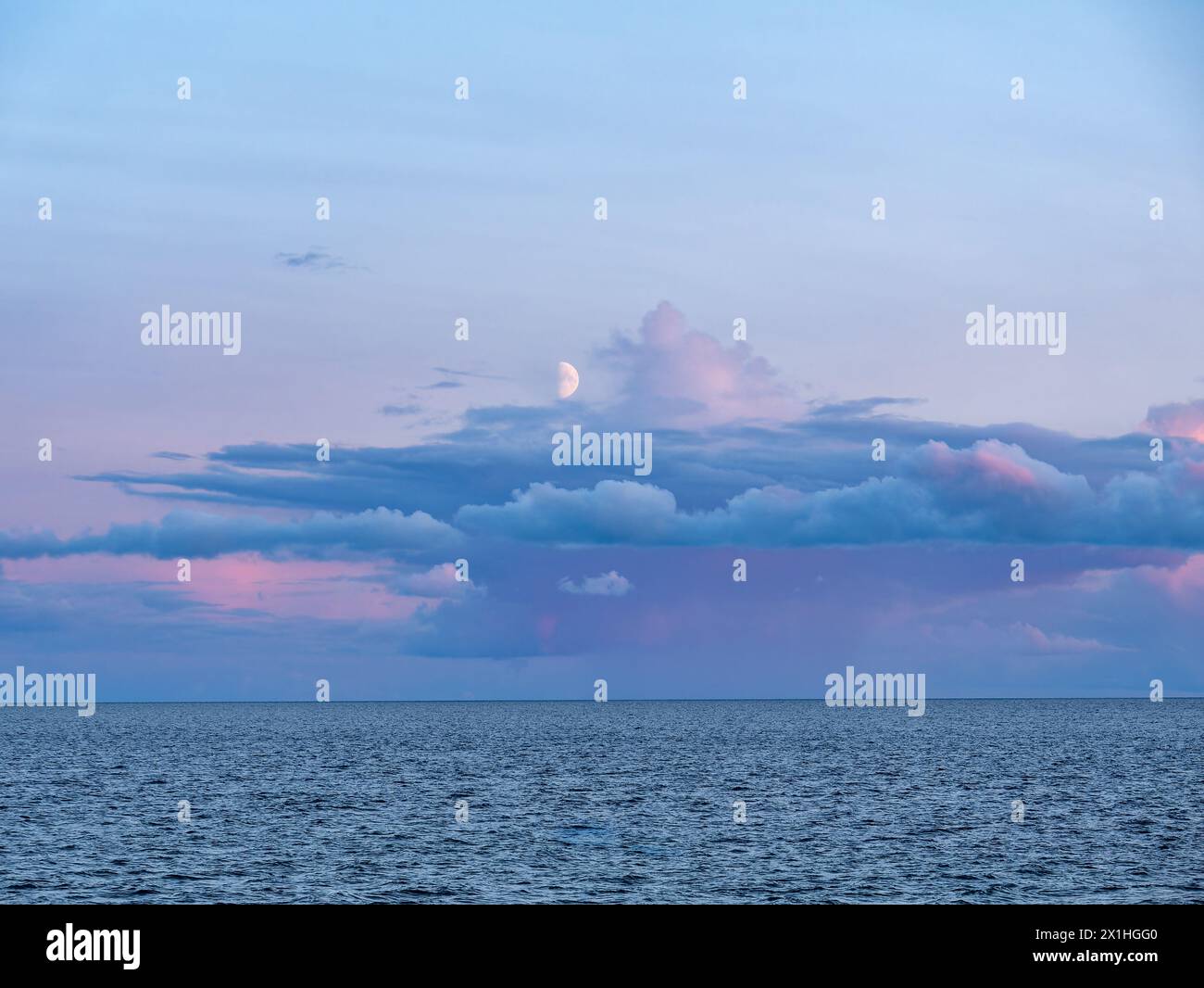 First quarter moon and rain clouds at dusk over Kattegat from Tunø ...