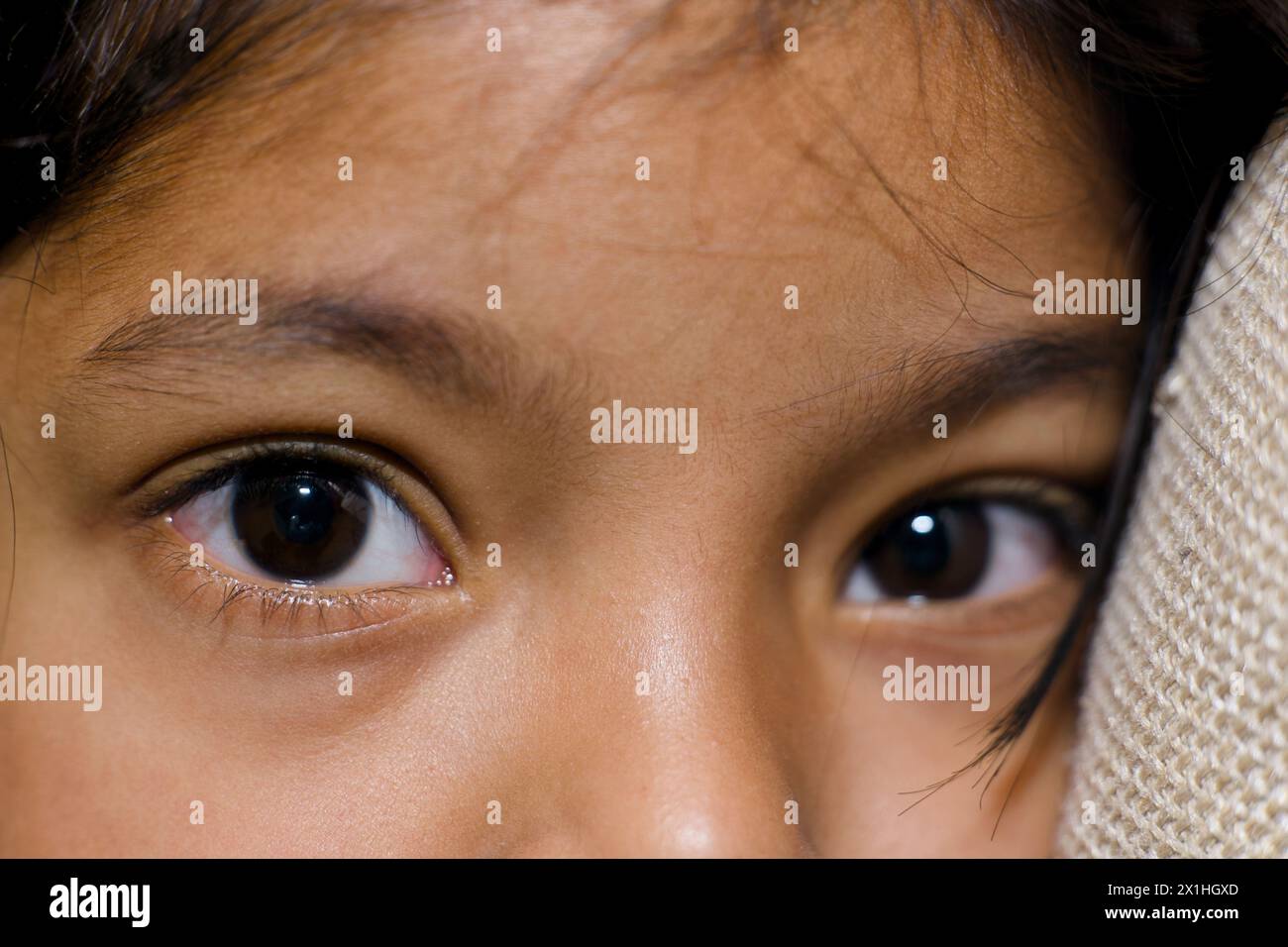 A close-up portrait of a young girl's eyes, brimming with ...