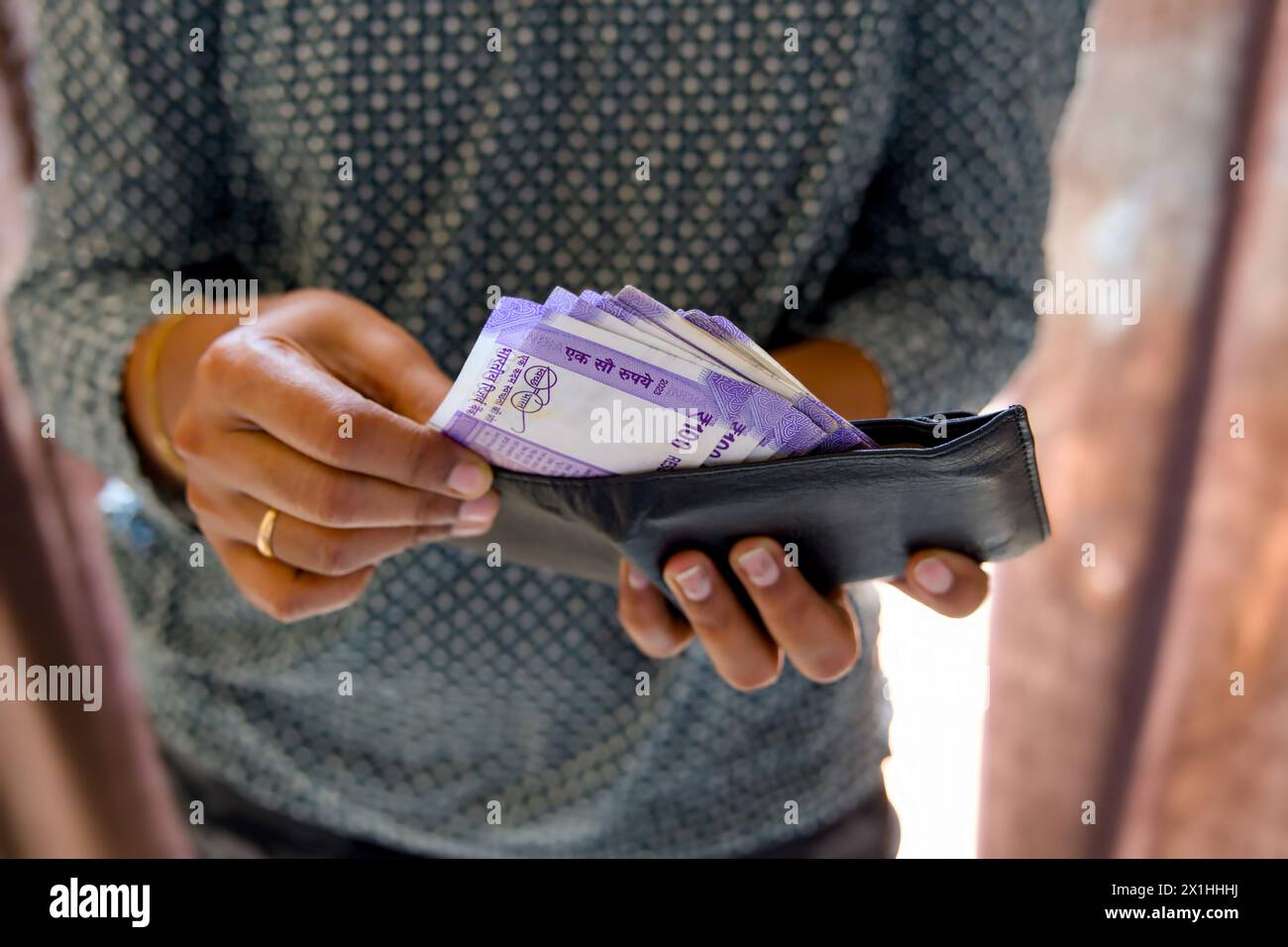 Close-up photo of a woman's hand opening a wallet filled with Indian ...