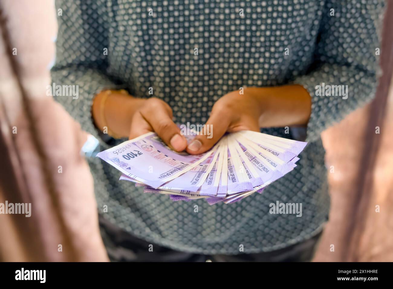 A close-up photo of a woman's hands meticulously counting stacks of ...