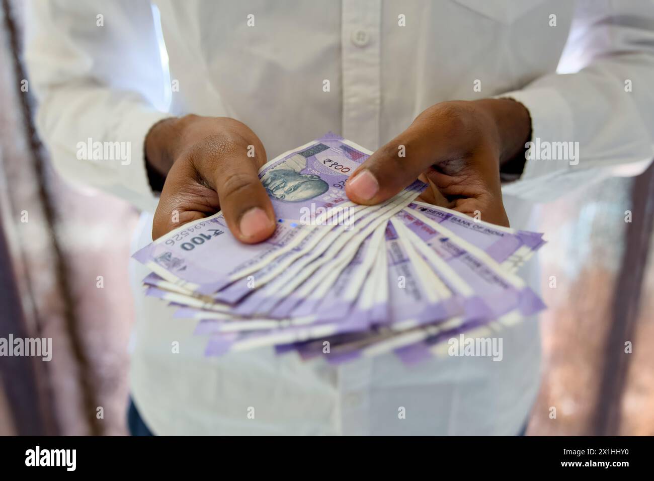 Close-up of businessman's hands meticulously counting stacks of 100 ...