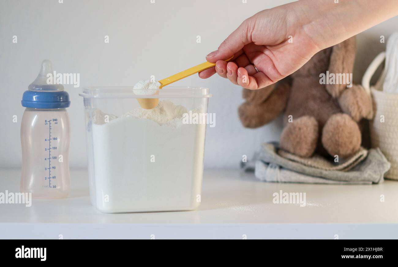 Dry powder formula milk for feeding babies in a can and mothers hand ...