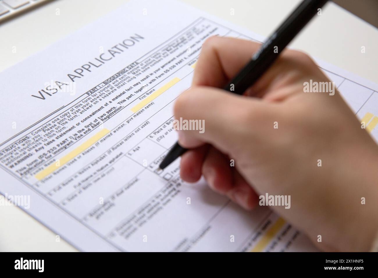 Close up of a female hand filling out a visa application document Stock ...