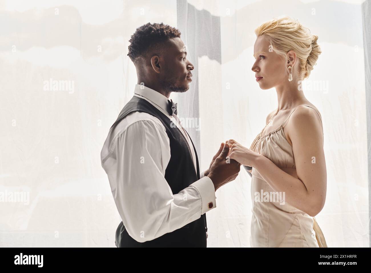 A beautiful blonde bride in a wedding dress and an African American ...