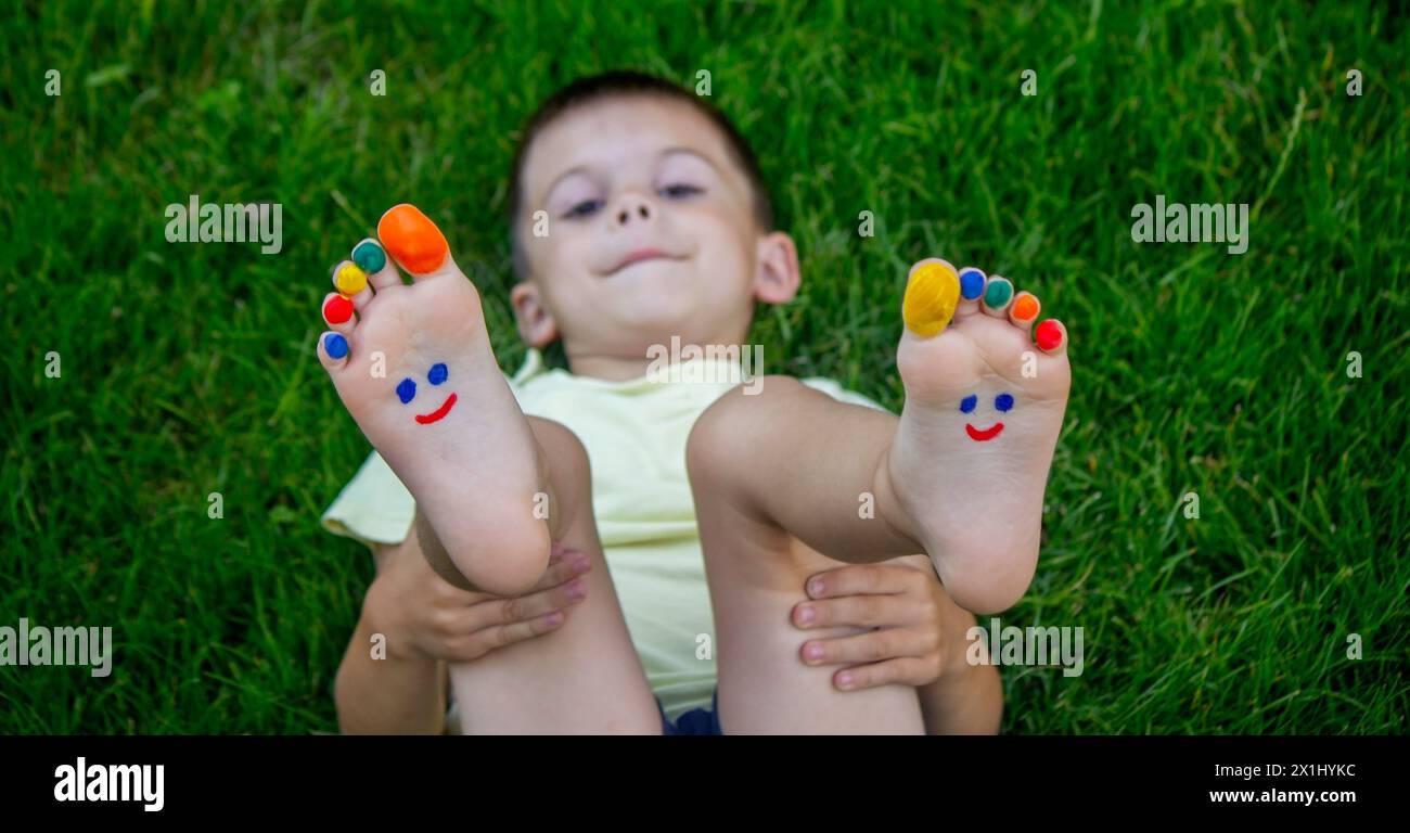 a smile drawn with paints on a child's legs Stock Photo - Alamy