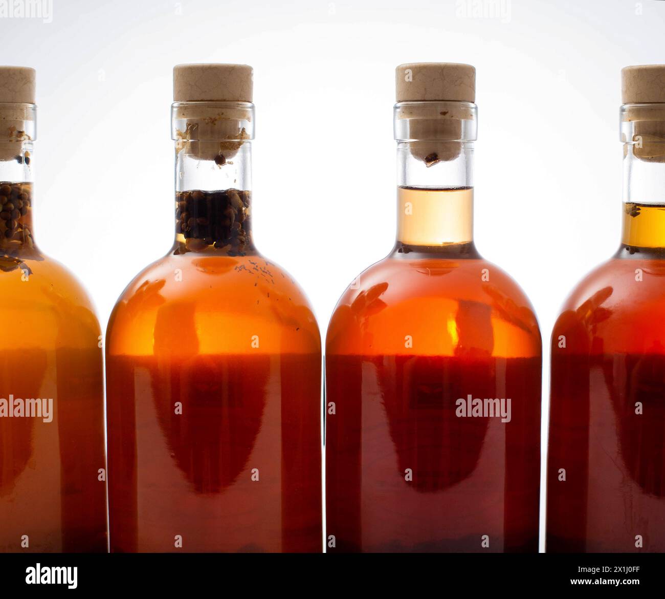 Bottles with transparent brown alcoholic drink on a white background ...