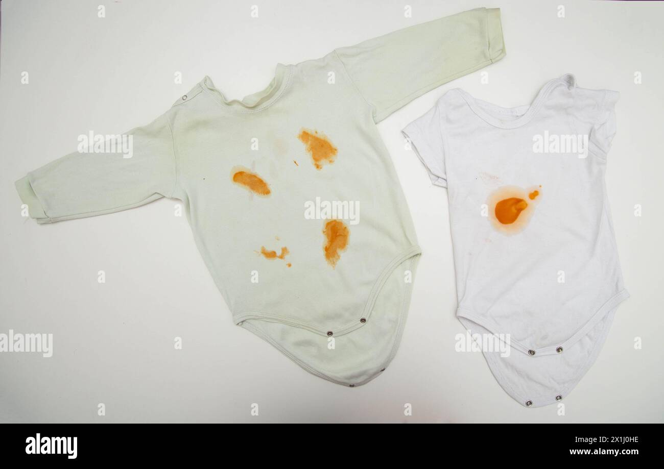 Orange stains on children's clothes from fruit puree. The concept of ...