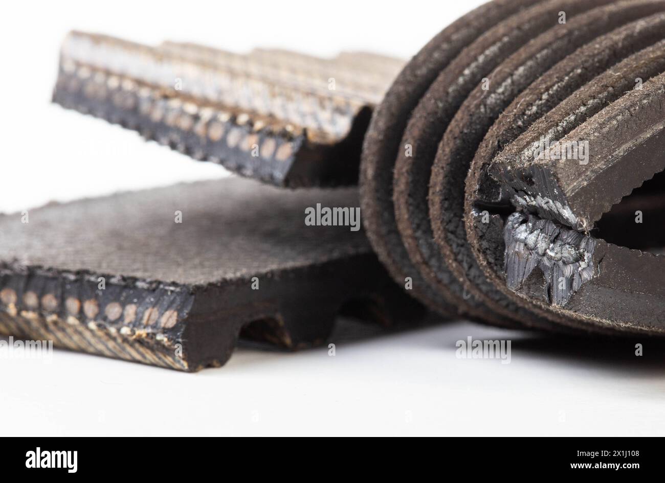 Torn timing belt and generator rivulet belt on a white background ...