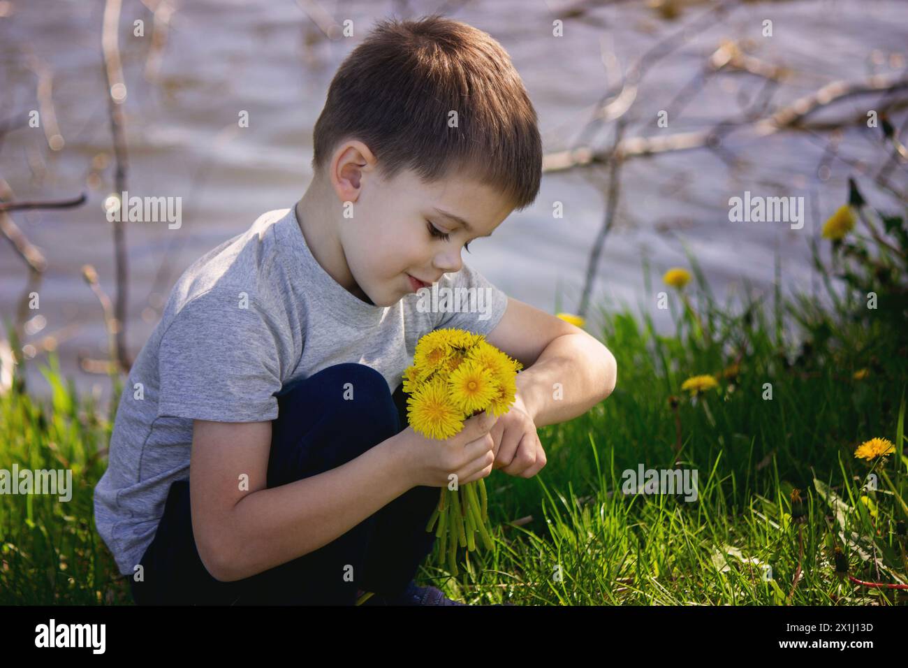 Funny baby sniffs a dandelion. Spring in nature. Allergy to flowering ...