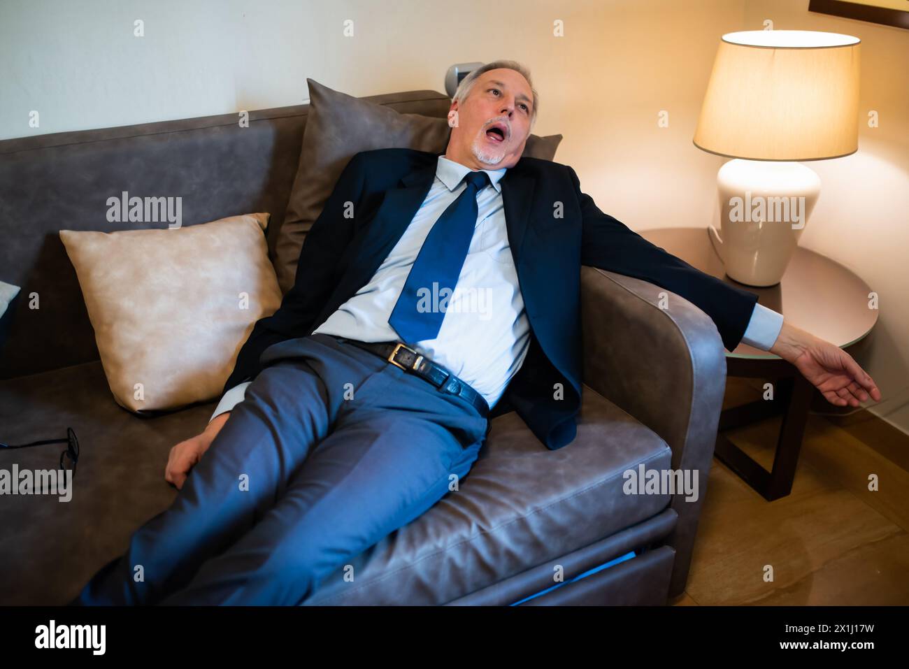 Dead businessman on the couch, stress and exhaustion concept Stock ...