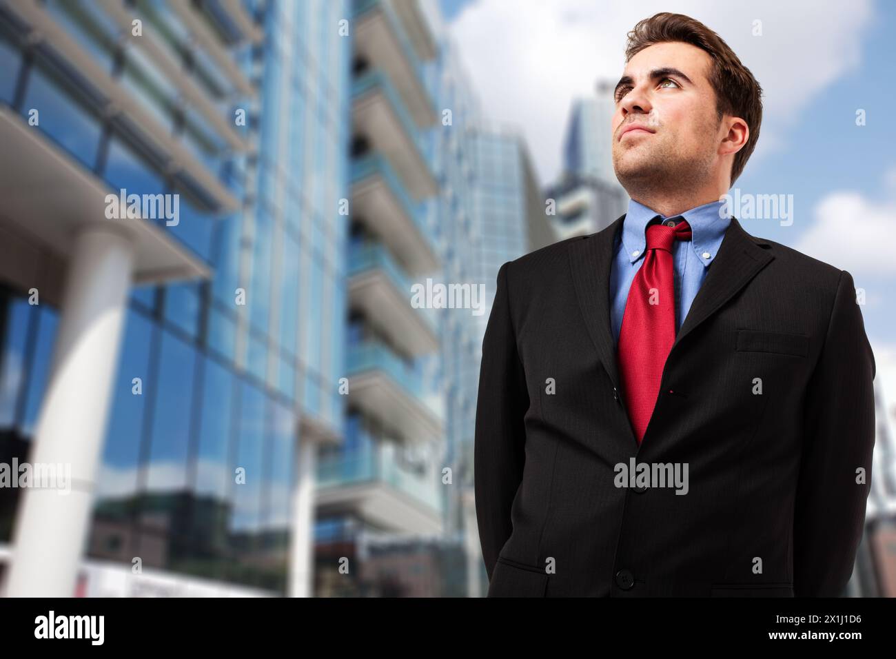 Young male professional stands confidently outside modern office ...
