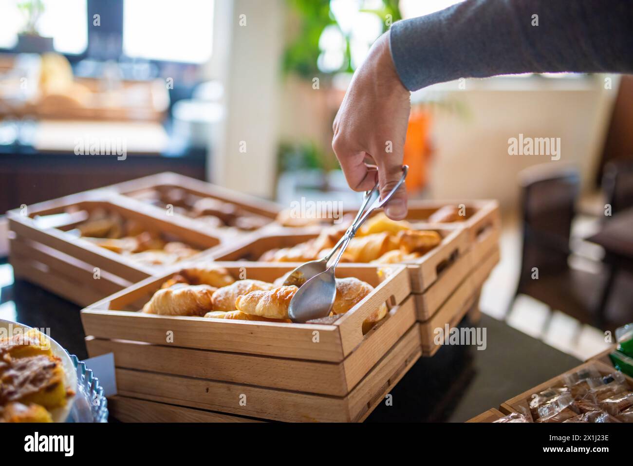 Hotel breakfast, man taking a bun from a buffet Stock Photo - Alamy