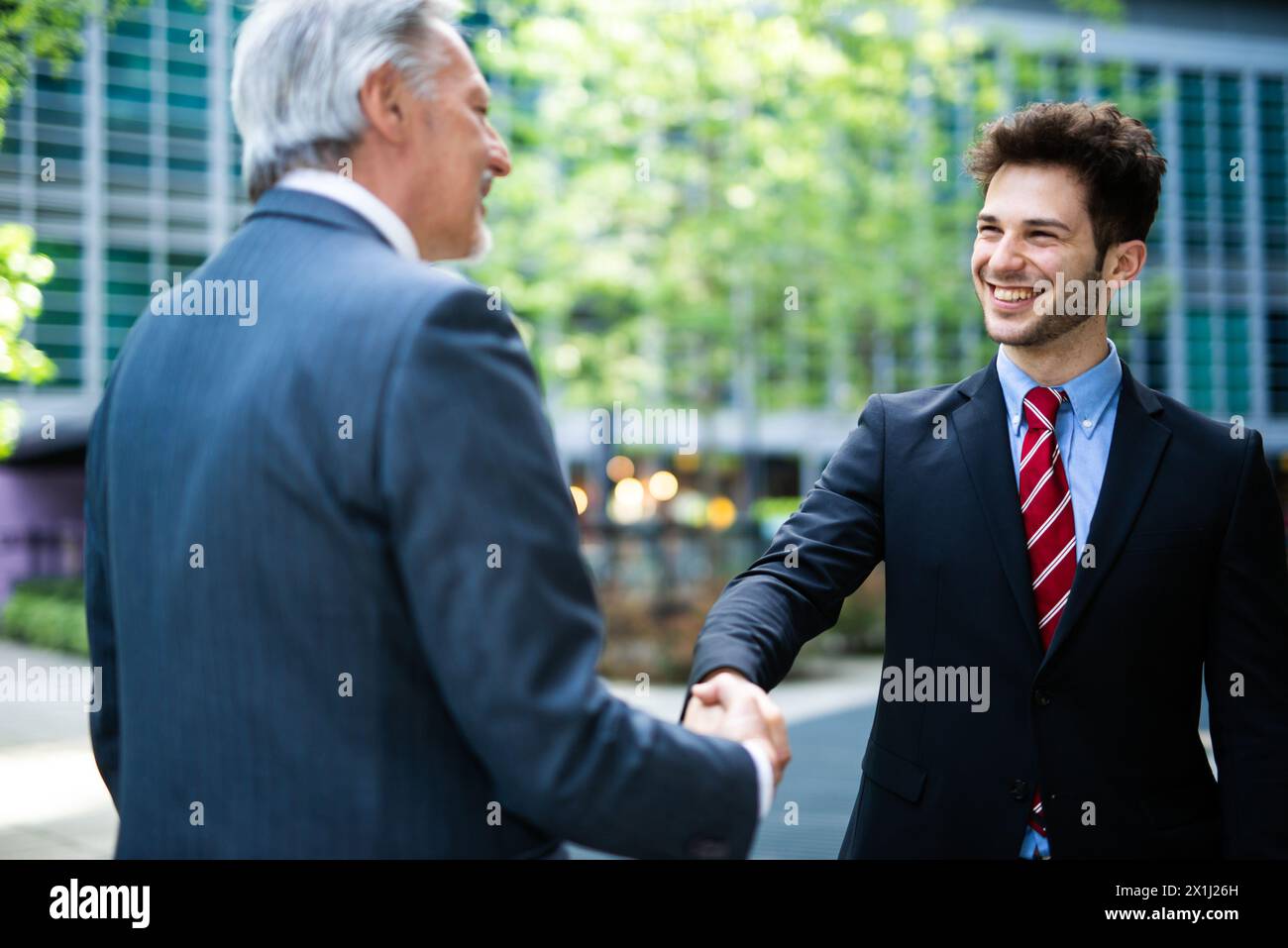 Handshake between business people outdoor Stock Photo - Alamy