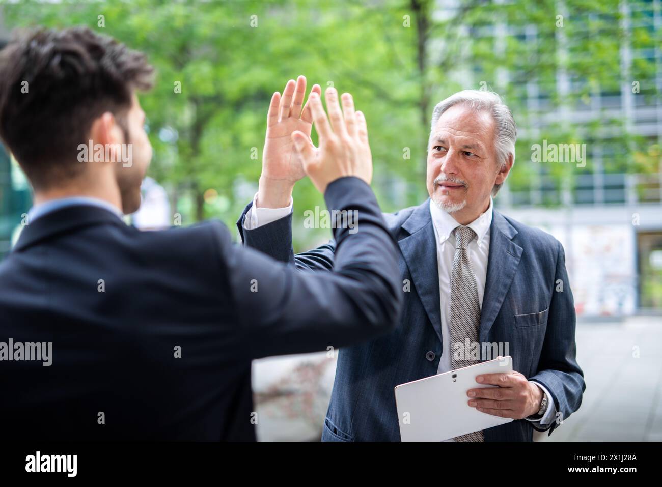 Business partners giving a high five, success concept Stock Photo - Alamy