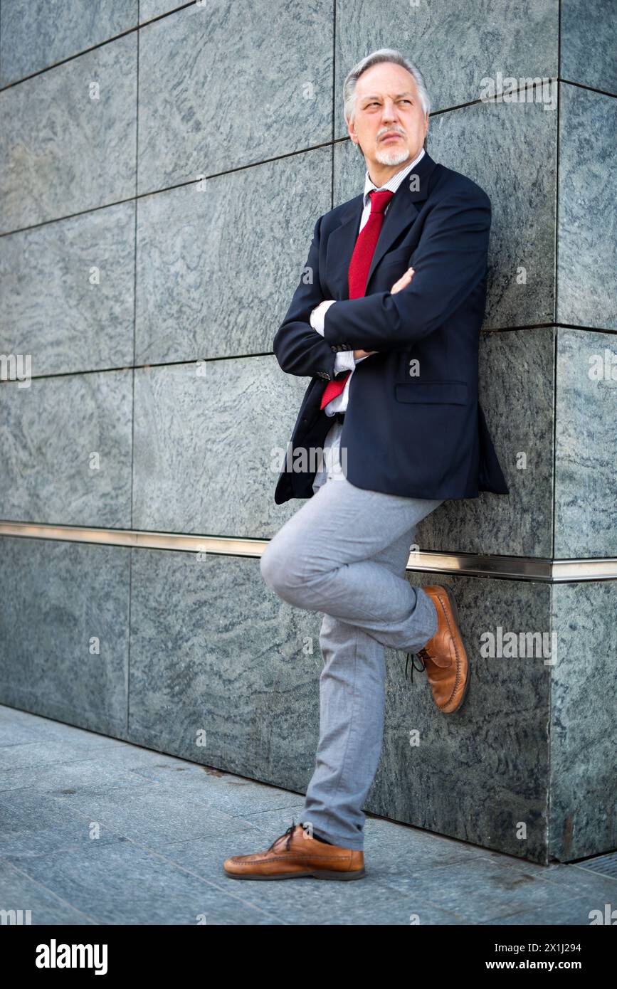 Thoughtful mature business man full length portrait outdoor Stock Photo ...