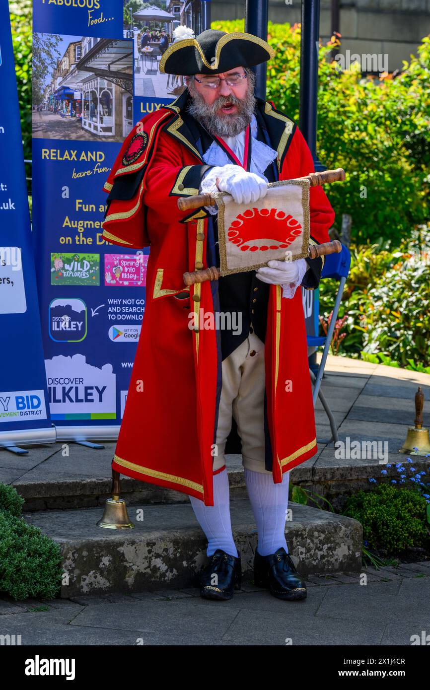 Male town crier (colourful crier's uniform, loud voice) proclaiming ...