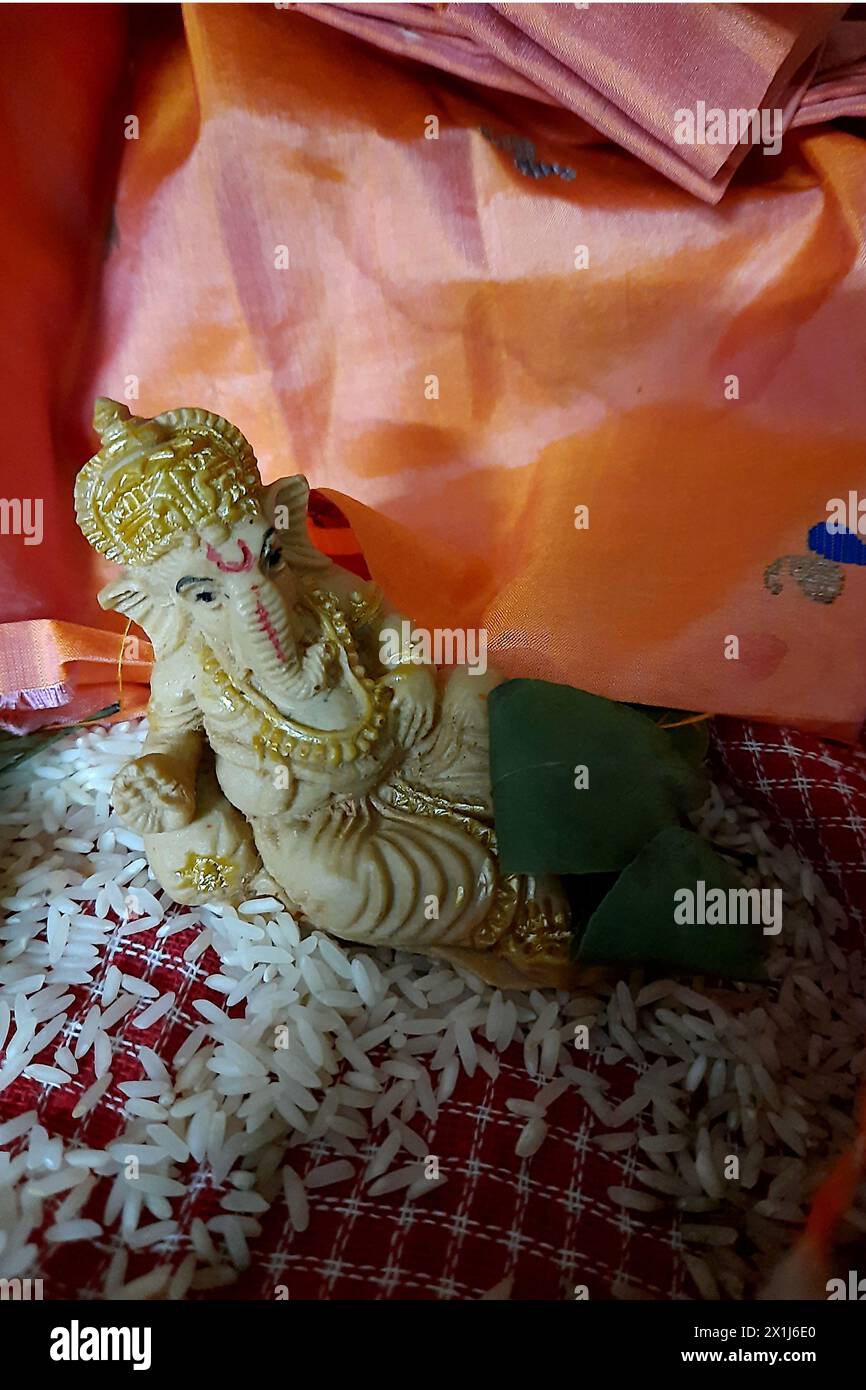 View of arrangement for puja of reclining Ganesha placed on red cloth ...