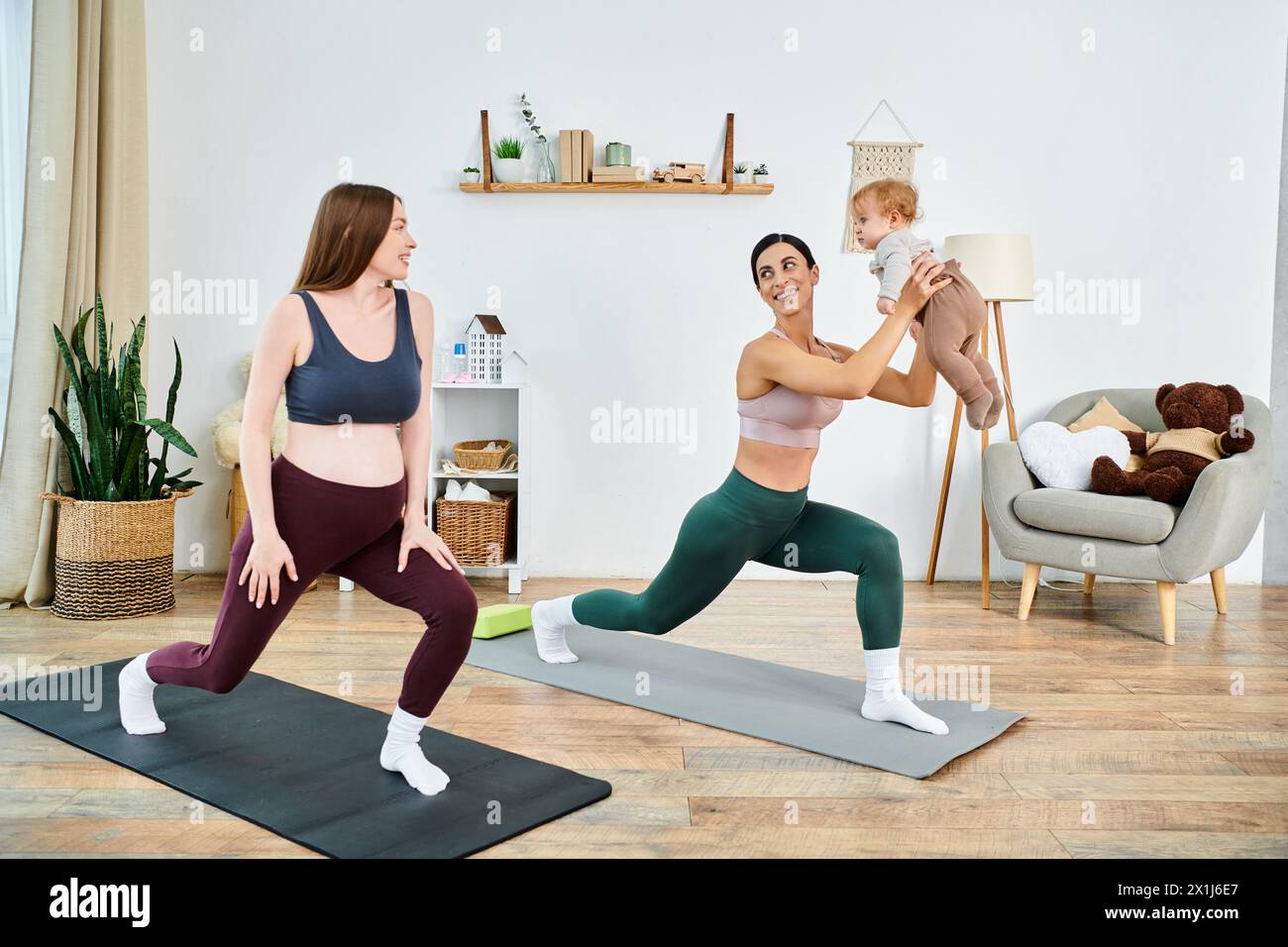 A young mother and her baby practice yoga together in the comfort of ...