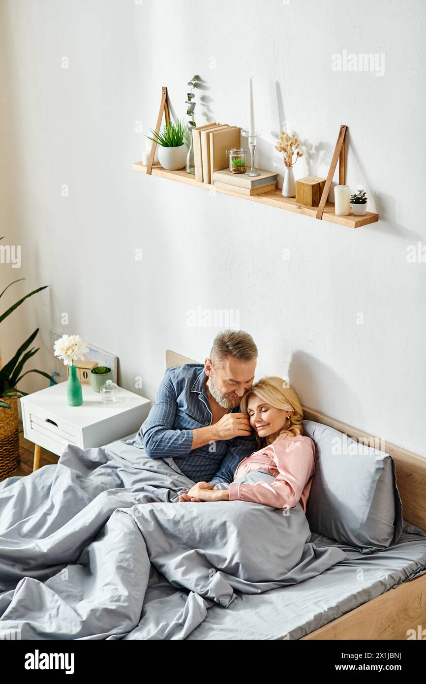 A Mature Man And Woman In Cozy Homewear Laying Together On A Bed Sharing A Moment Of Intimacy