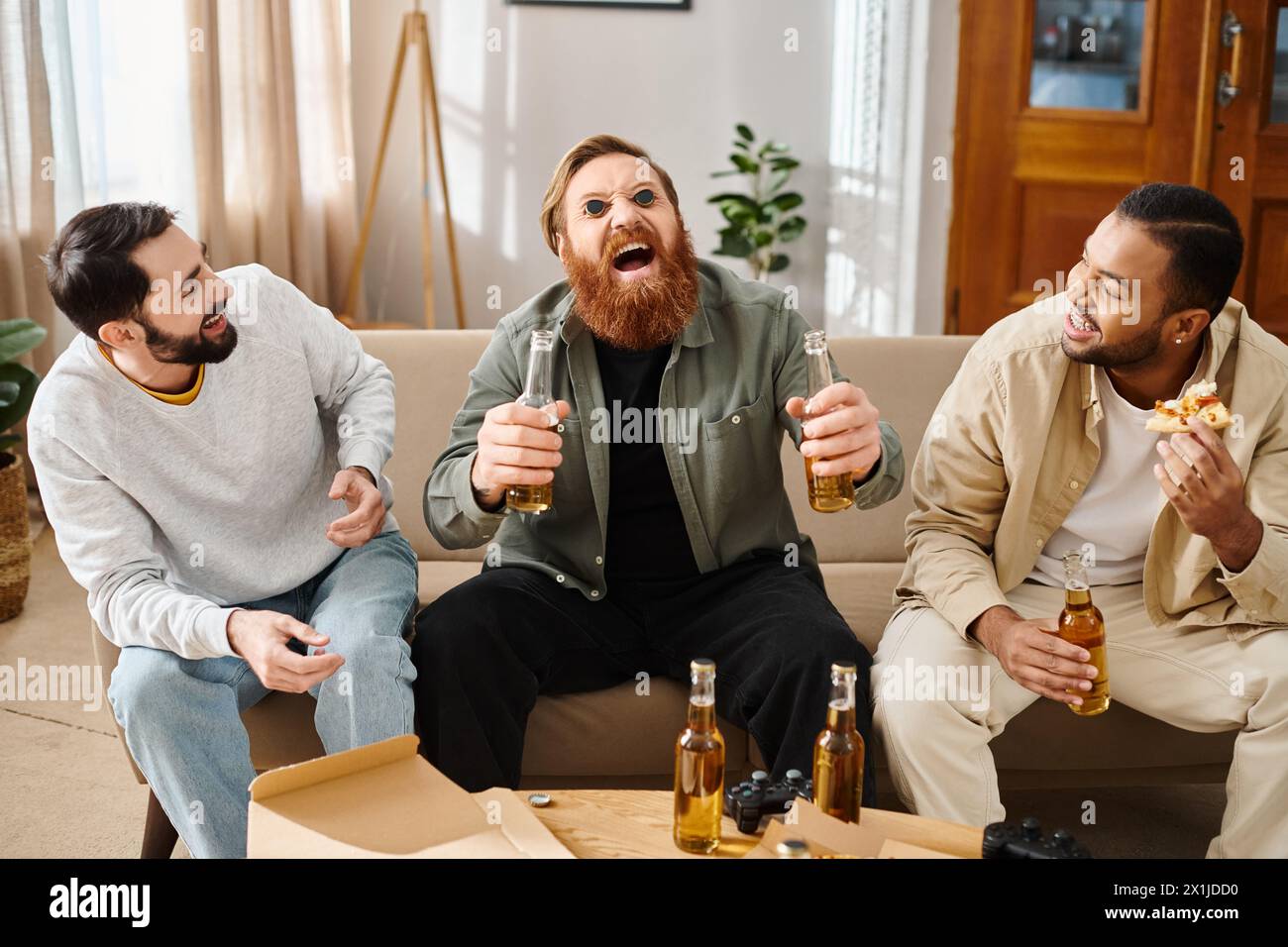 Three handsome, cheerful men of different races sit on a couch ...