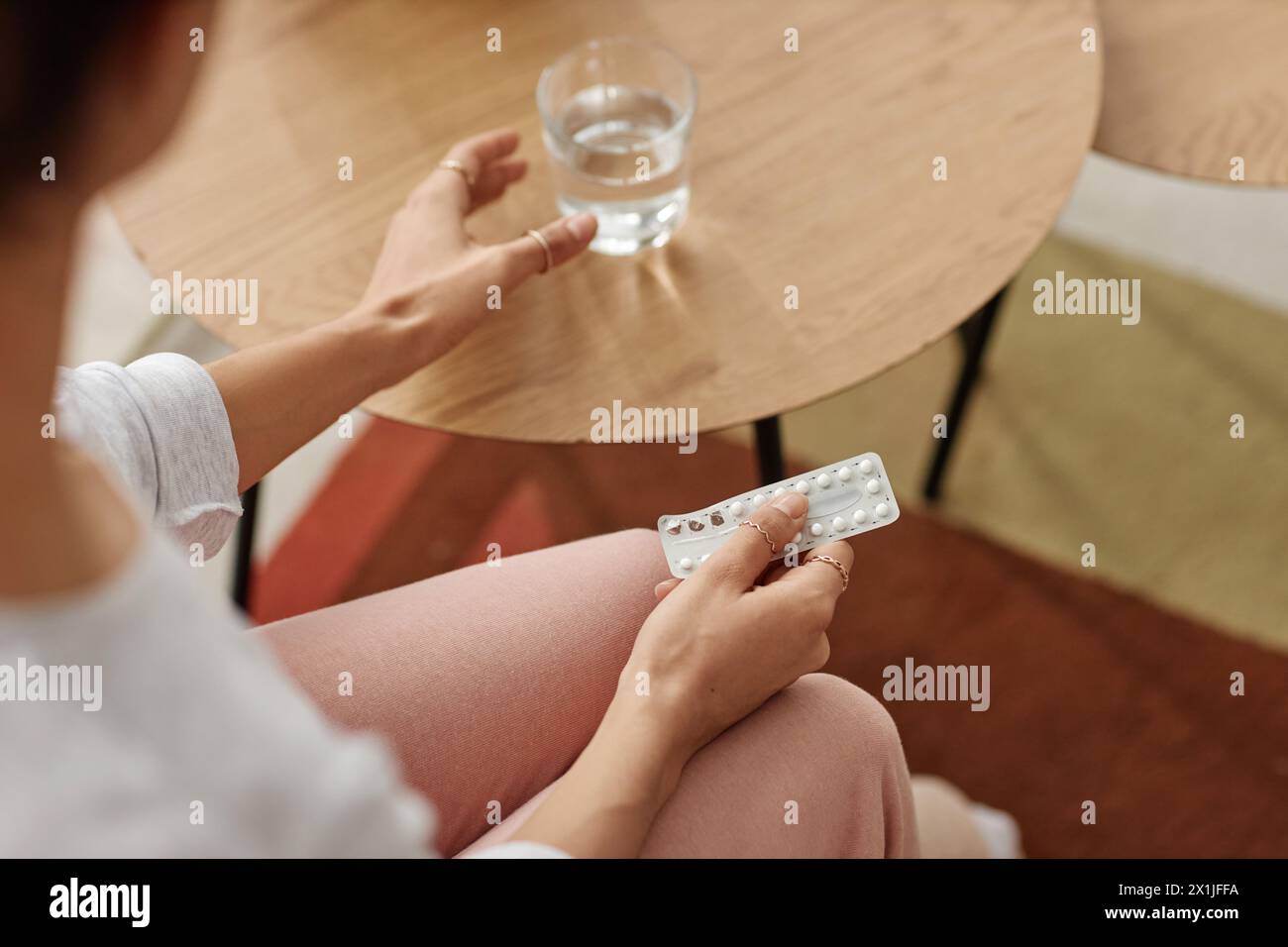 Top view closeup of unrecognizable woman taking medication at home and ...