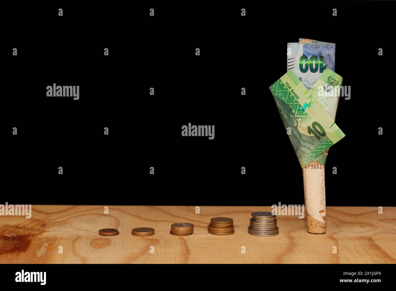 wood desk black background coins stacked in a row with a money tree ...